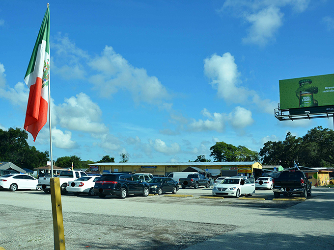 The parking lot—first challenge in your treasure hunting adventure. Mexican and American flags wave in welcome, promising international flavors inside.