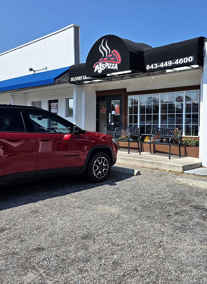 The parking lot view that locals know by heart – where your car waits patiently while you indulge in what might be the best pizza decision of your vacation.
