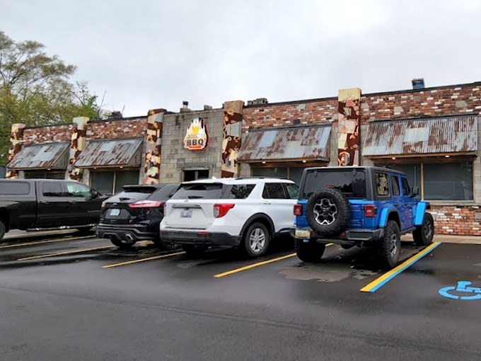 The parking lot view that promises salvation from hunger. Those flames on the building aren't just decoration—they're a beacon for barbecue pilgrims.
