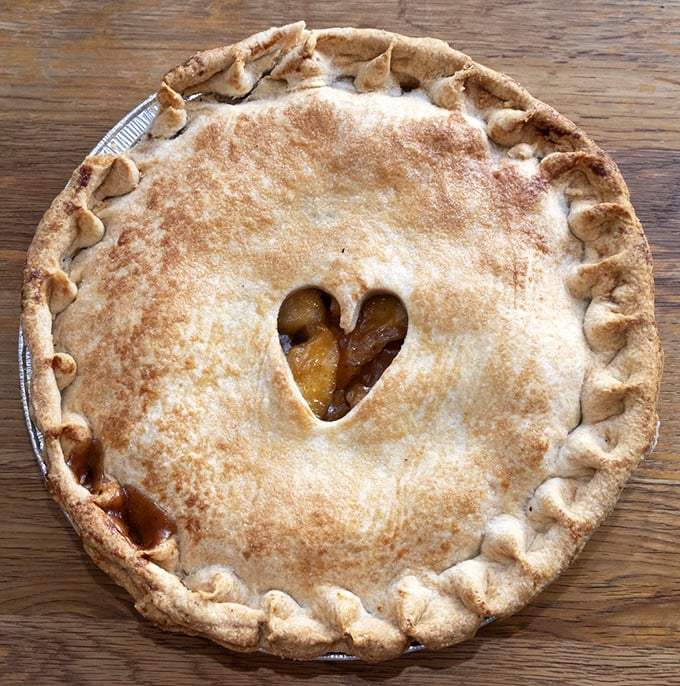 The heart-shaped window in this apple pie crust isn't just cute—it's a steam vent of love, releasing the aroma of cinnamon-kissed apples that makes resistance futile.