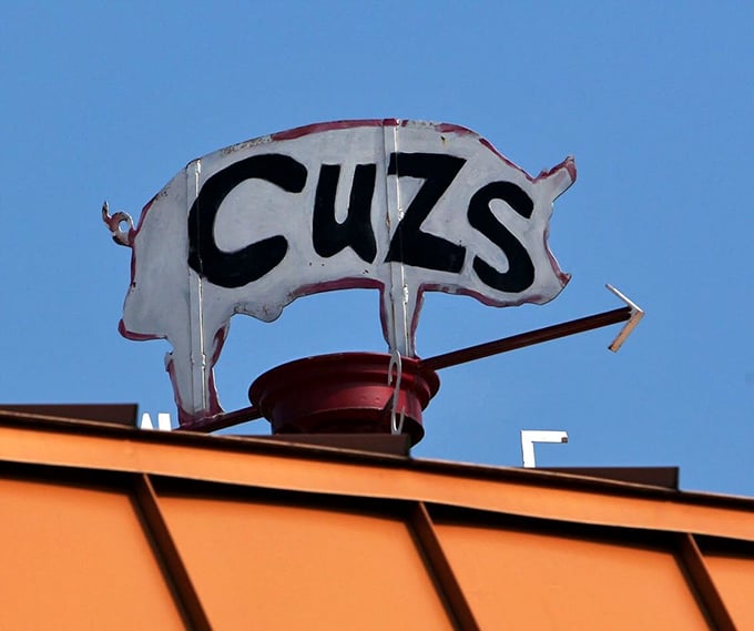 The iconic Cuz's pig sign—a simple silhouette that has guided hungry travelers like a porcine North Star for generations.