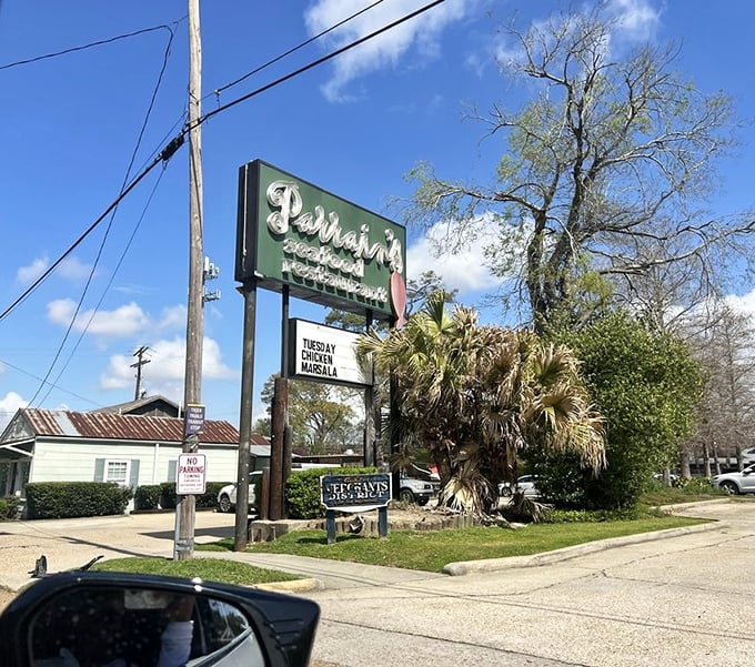 The Parrain's sign stands tall against the blue Louisiana sky, a beacon guiding hungry travelers to seafood salvation.