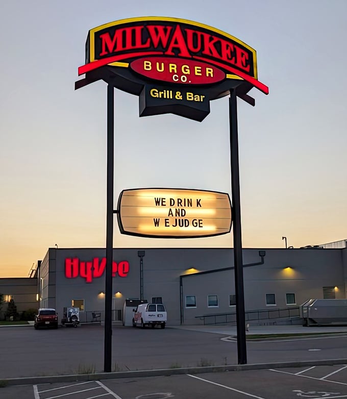 "WE DRINK AND WE JUDGE"—the illuminated sign speaks truth to power as dusk settles over Eau Claire's favorite burger joint.