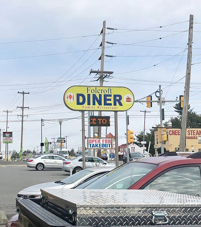 The roadside sign stands tall, a beacon of hope for hungry travelers and locals alike. No GPS needed—just follow your appetite.