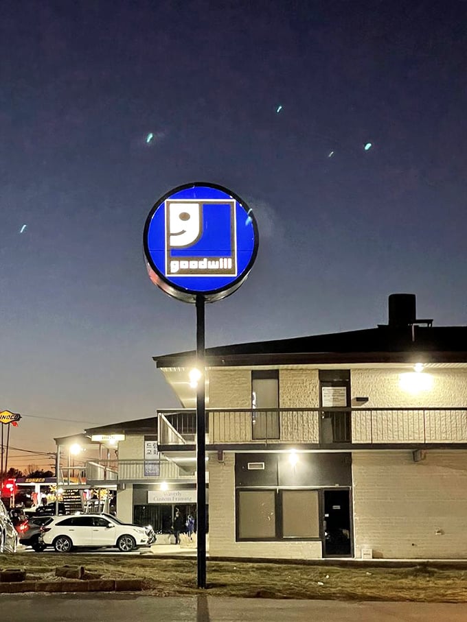 The Goodwill sign glowing against the evening sky like a beacon guiding bargain hunters safely home to savings paradise.