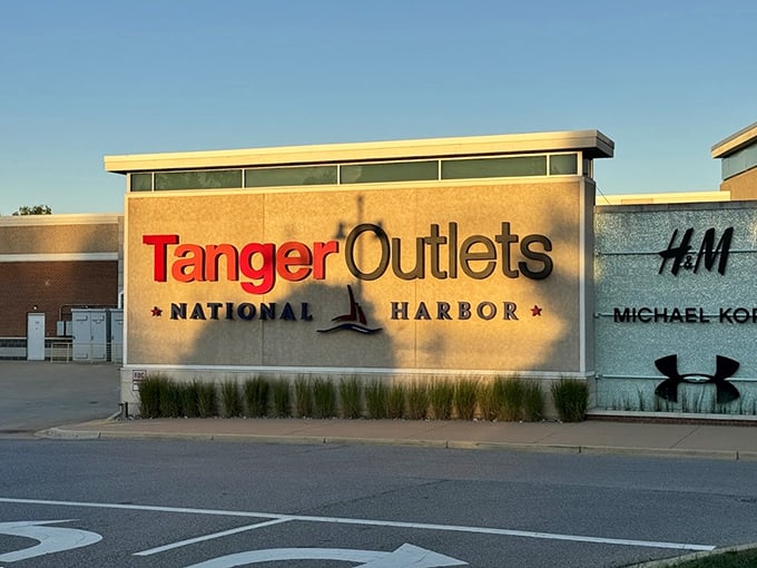 The golden hour glow on Tanger's entrance sign—a retail sunset that promises designer labels without designer prices just beyond those automatic doors.