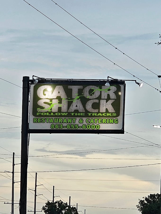 The Gator Shack sign glows against the twilight sky, beckoning hungry travelers to "Follow The Tracks" to authentic Florida flavor.