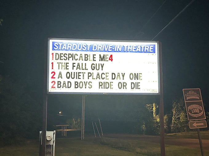 The illuminated marquee announces tonight's double features, a glowing beacon calling movie lovers from miles around to gather under the stars.