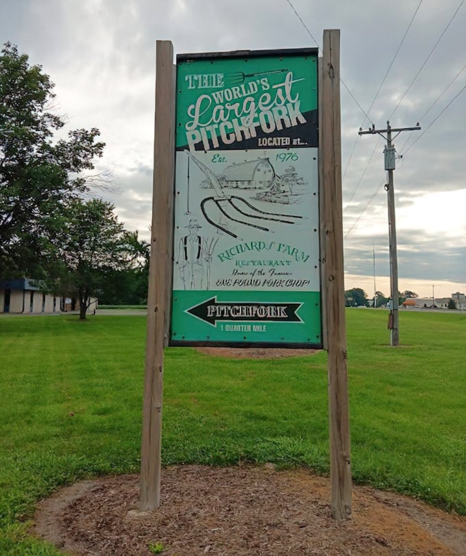 The vintage-style sign points travelers toward agricultural enormity—proof that sometimes the journey's best surprises come with excellent roadside advertising.