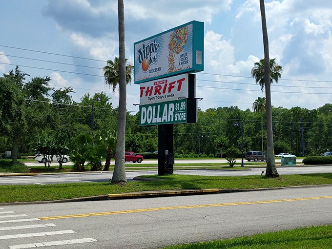 The roadside sign stands tall among palm trees, a beacon for bargain hunters navigating Kissimmee's tourist-heavy landscape toward authentic local treasure.