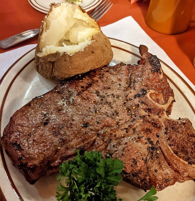 A perfectly grilled pork chop with a baked potato so fluffy it could double as a pillow—comfort food elevated to an art form.