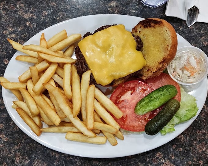 The burger that launched a thousand napkins – melted cheese, golden fries, and all the fixings arranged with unpretentious precision.