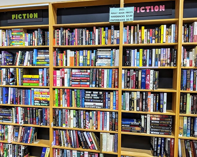 Fiction shelves packed tighter than a bestseller's plot twists—each book waiting for its next chapter with a new owner.