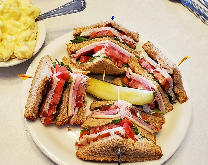 A club sandwich built like a skyscraper of deliciousness. The toothpicks aren't decoration – they're structural engineering.