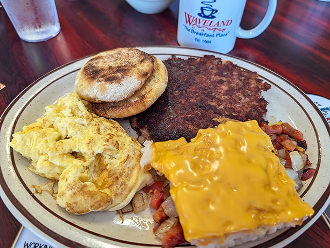 The breakfast plate that has it all—golden eggs, English muffin, crispy hashbrowns with melted cheese, and what appears to be corned beef hash. A complete morning symphony.