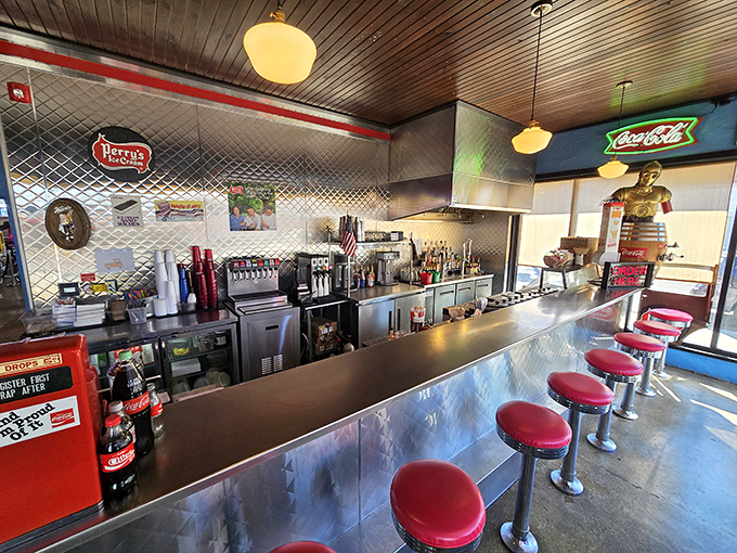 The counter where magic happens—red stools lined up like patient soldiers waiting for hungry patrons to claim their front-row seats.