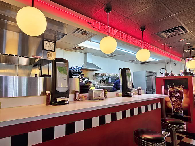 The counter where dreams come true, one order at a time. That red neon glow isn't just lighting—it's anticipation made visible.