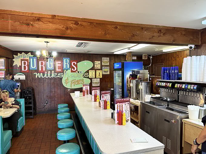 The counter seating area—where solo diners become regulars, milkshake machines hum their soothing song, and "BURGERS" signs state the obvious deliciously.
