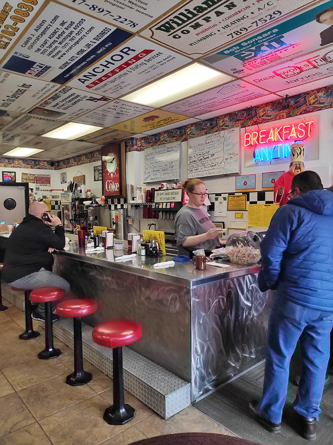 The counter – where breakfast magic happens. Those red stools have supported generations of hungry patrons waiting for their slice of diner heaven.