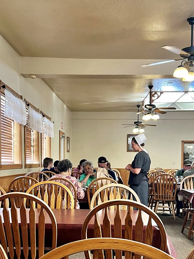 The dining room hums with the universal language of satisfaction—forks meeting plates while Amish servers deliver the next round of edible joy.