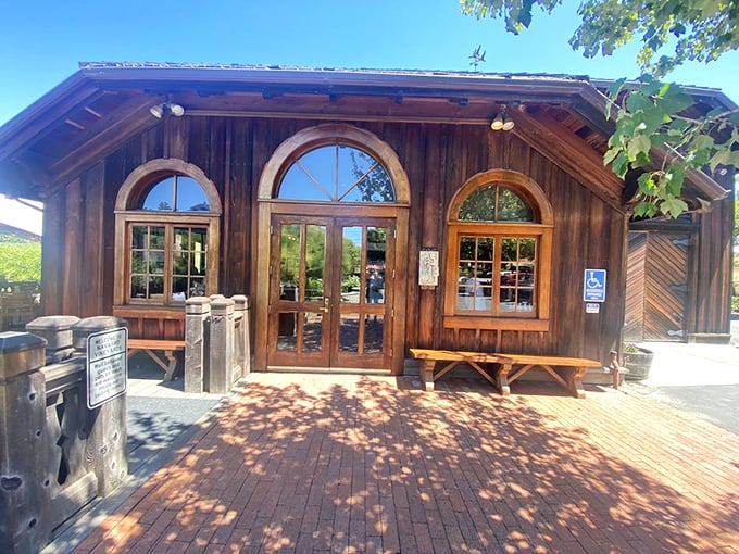 Rustic wooden architecture with arched windows welcomes visitors – like a storybook cottage that happens to serve exceptional wine.