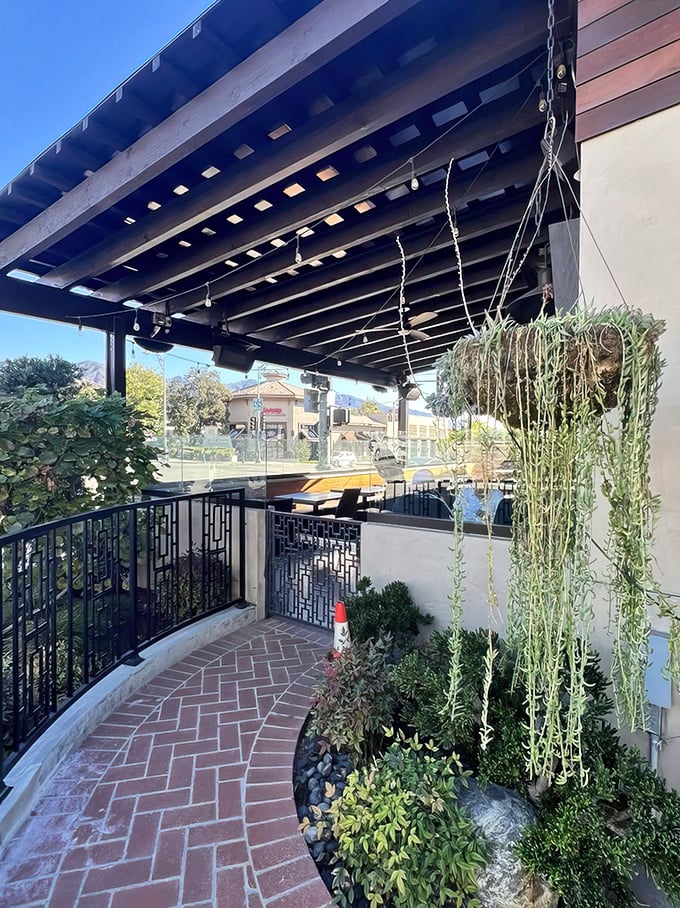 A charming entrance pathway lined with greenery and string lights. The kind of welcoming approach that promises good things are waiting just around the corner.