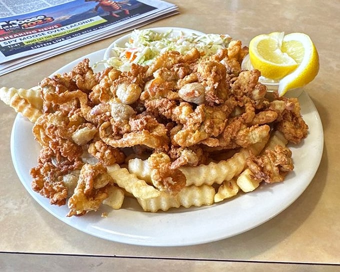 The ocean meets the fryer in perfect harmony—golden-battered clams and crinkle-cut fries create a New England classic that never disappoints.