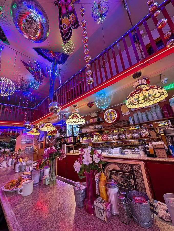 The counter view—where coffee mugs steam, condiments stand at attention, and Tiffany lamps cast a warm glow over your impending food coma.