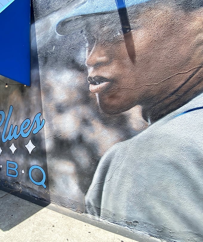 This striking mural outside Baby Blues BBQ isn't just decoration – it's a soulful promise of the authentic Southern experience waiting inside.