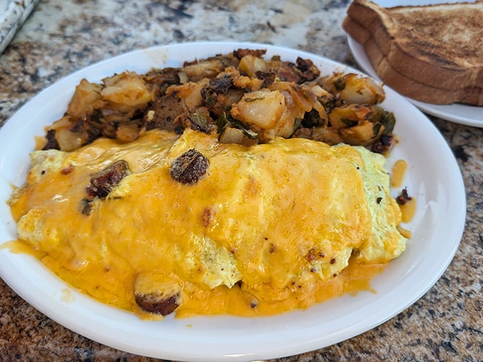 This isn't just an omelet—it's a cheese-blanketed treasure chest hiding savory secrets beneath its golden exterior.