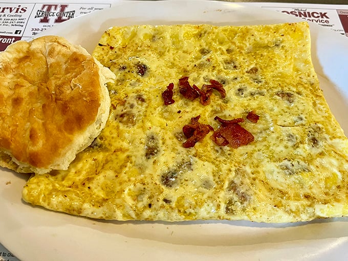 An omelet so perfectly executed it deserves its own cooking show. That biscuit on the side isn't just a sidekick – it's a co-star.