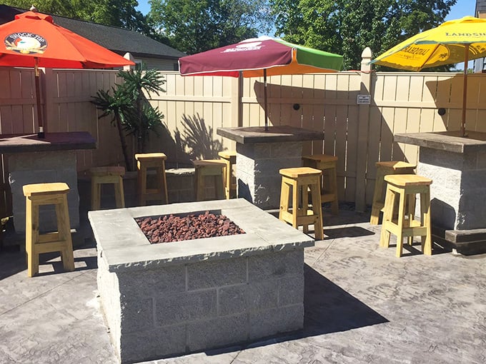 Fire pit, wooden stools, and colorful umbrellas—the outdoor patio isn't just an addition, it's where summer memories are crafted one wing at a time.