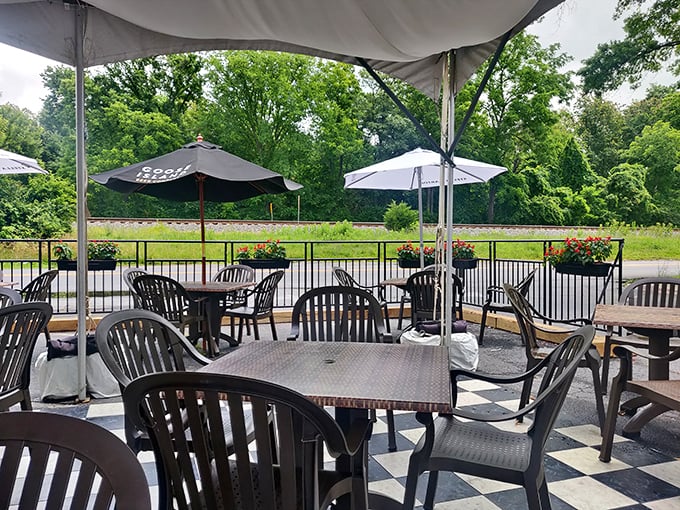 The outdoor seating area offers a peaceful retreat with umbrellas for shade and greenery all around—nature's dining room.