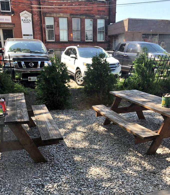 The outdoor seating area – where picnic tables and evergreens create a rustic backdrop for the serious business of barbecue appreciation.