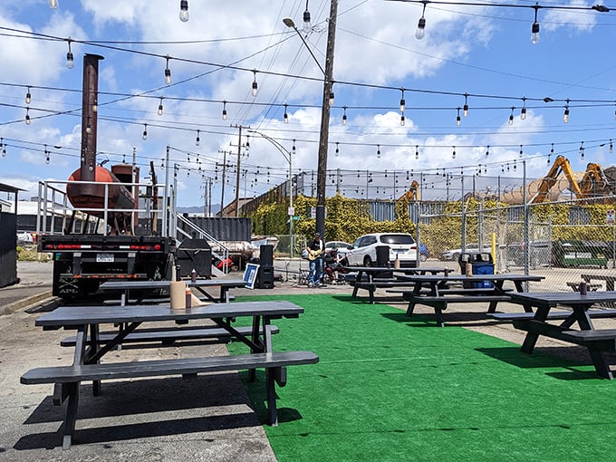 The outdoor seating area, complete with string lights and smokers, feels like the backyard barbecue of your dreams—if your dreams had better equipment.