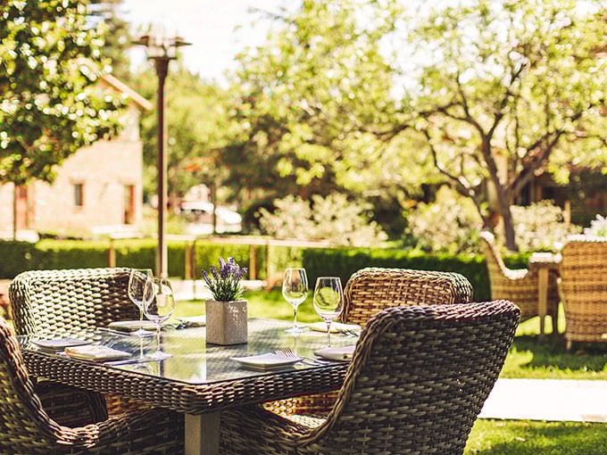 Garden dining that captures California's indoor-outdoor lifestyle – where wine glasses await filling with local vintages under dappled sunlight.