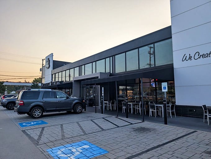As evening approaches, the bakery's sleek exterior glows with welcome. Those outdoor tables invite lingering conversations over coffee and crumbs.