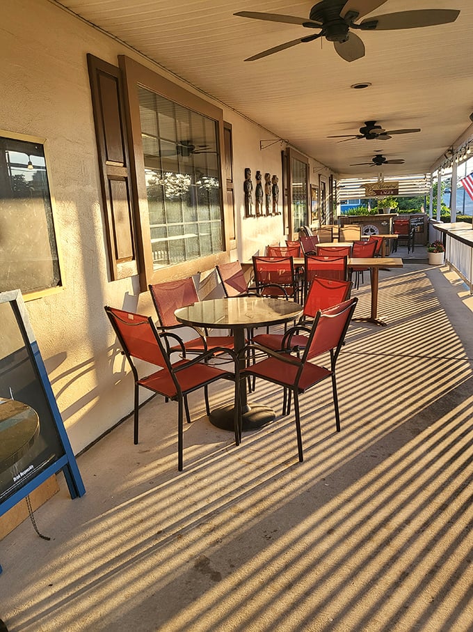 The porch seating area catches golden hour light like it was designed by a cinematographer. Those shadows create natural zebra stripes across your dining experience.