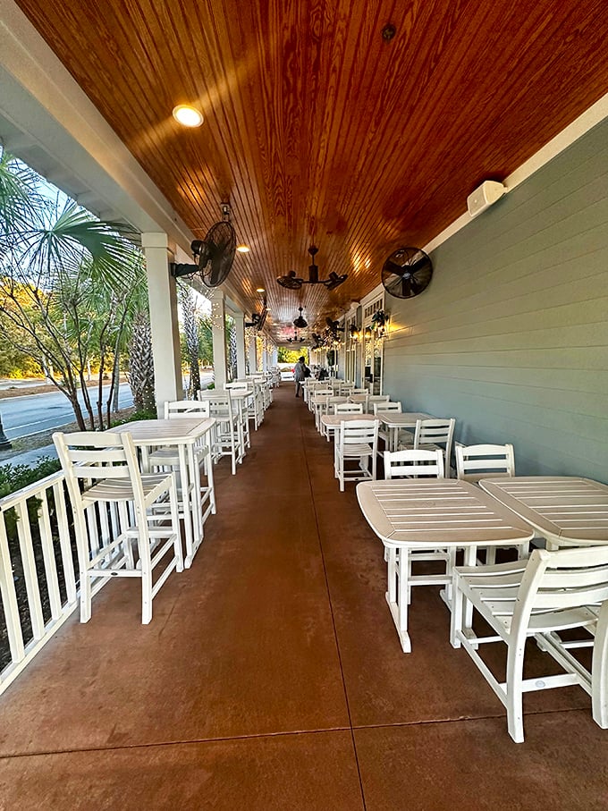 The outdoor seating area offers al fresco dining with a side of Southern charm—wooden ceiling, ceiling fans, and white rocking chairs that practically demand you slow down.