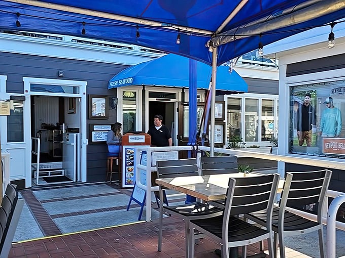 The welcoming outdoor patio beckons with its blue awning and wooden tables – the perfect spot to people-watch while waiting for your clam chowder fix.