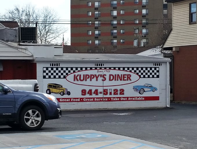 The iconic checkerboard trim and vintage car imagery on Kuppy's exterior wall isn't just decoration—it's a promise that inside, time-honored traditions are still respected.