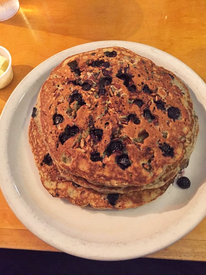 Blueberry pancakes stacked higher than your weekend expectations—these fluffy discs of joy are what breakfast dreams are made of.