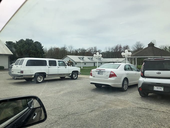 The parking lot—where vehicles wait patiently while their owners inside engage in the serious business of second helpings.