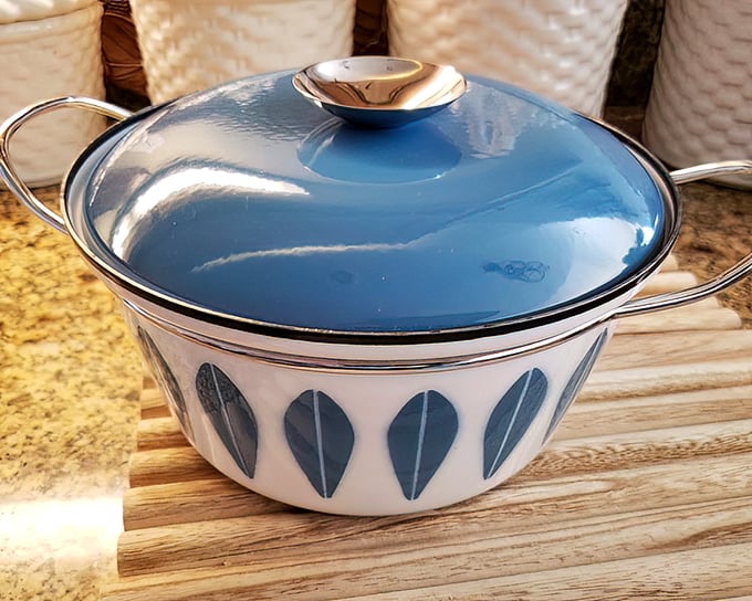 Mid-century modern meets kitchen functionality. This blue-lidded beauty once simmered someone's grandmother's famous stew—now it's ready for your culinary adventures.