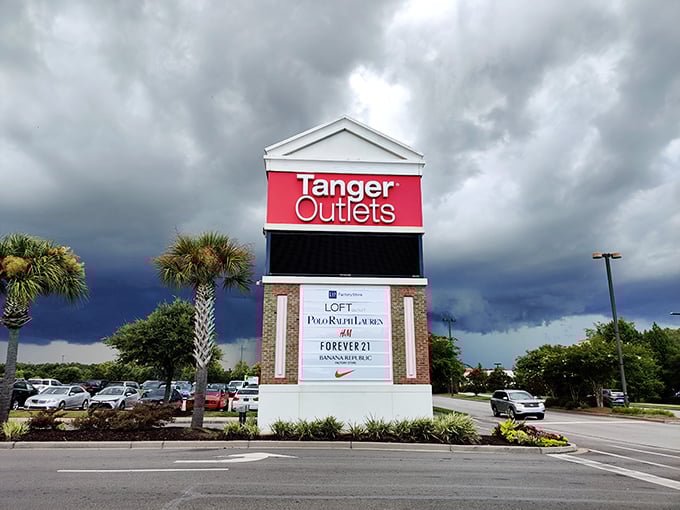The entrance sign stands like a retail lighthouse guiding bargain seekers safely to shore—promising Nike, Calvin Klein, and Forever 21 without the full-price pain.