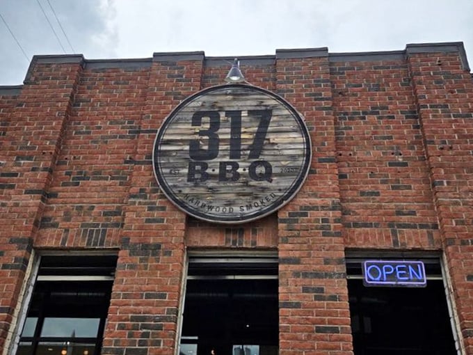 The weathered wooden sign against brick announces your arrival at barbecue headquarters – like a meaty North Star guiding hungry travelers home.