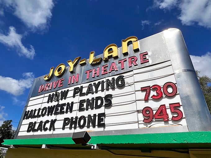 That iconic sign announces tonight's features in glowing letters, a beacon calling movie lovers to gather under the stars.