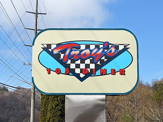 The roadside sign stands as a beacon of hope for hungry travelers – its checkered background promising that yes, you've found the real deal, not some chain restaurant imposter.