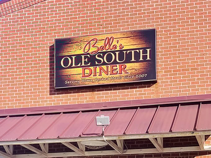 The sign glows against red brick like a Southern sunrise, announcing to hungry travelers that breakfast salvation awaits just beyond those doors.