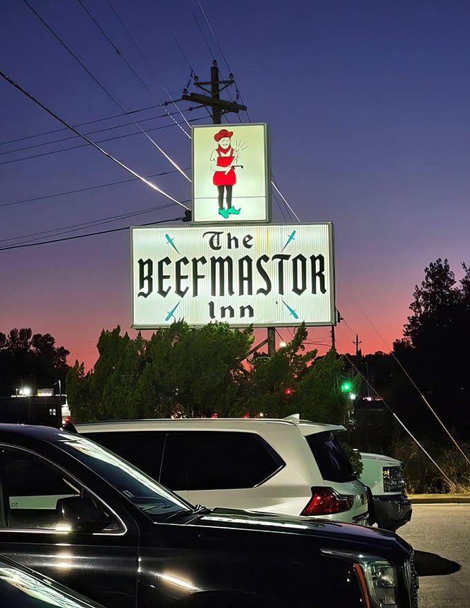 That neon sign against the twilight sky isn't just advertising—it's a beacon calling to carnivores from miles around.